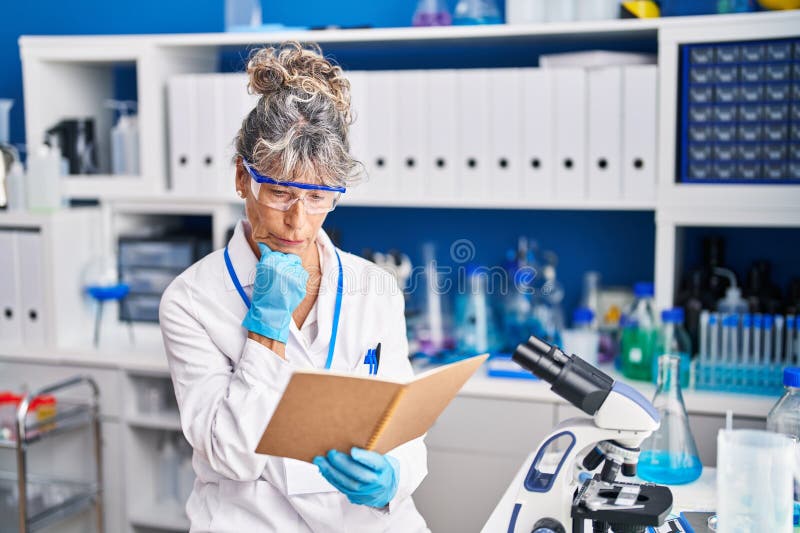 Middle Age Woman Scientist Reading Book at Laboratory Stock Image ...