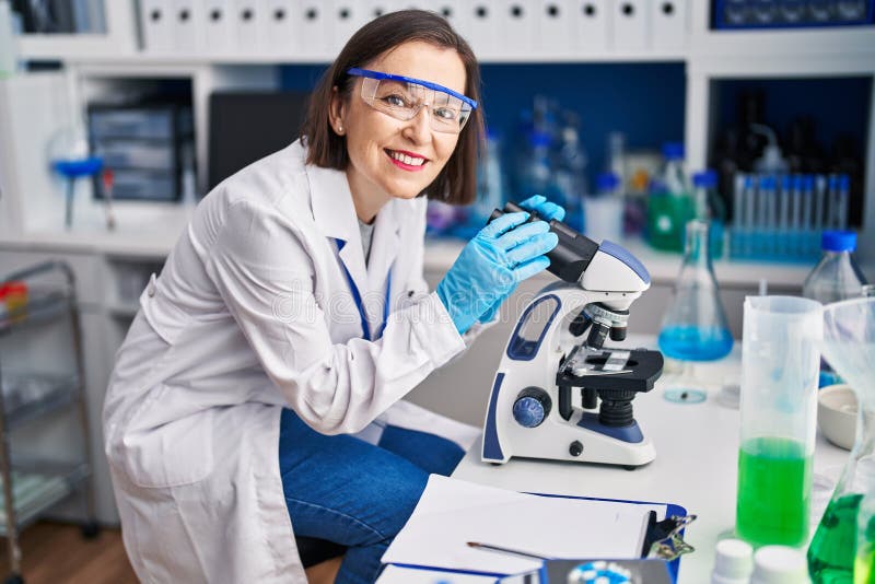 Middle Age Woman Scientist Smiling Confident Using Microscope at ...