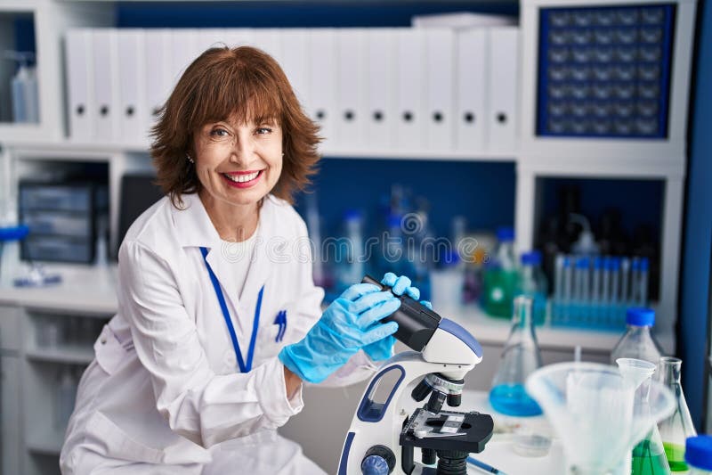 Middle Age Woman Scientist Using Microscope at Laboratory Stock Photo ...