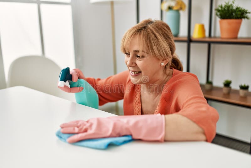 Middle Age Woman Smiling Happy Cleaning Using Diffuser and Rag at Home ...