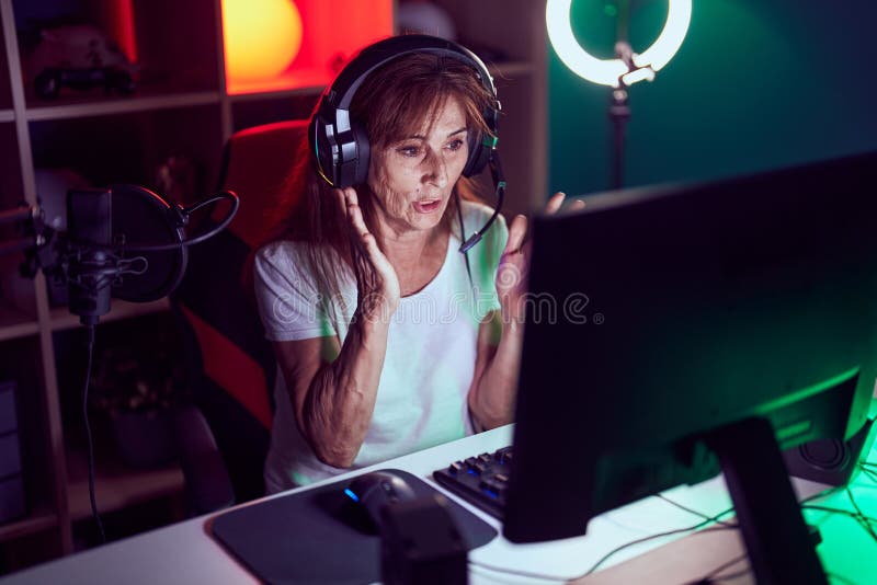 Middle Age Woman Streamer Playing Video Game Using Computer at Gaming ...