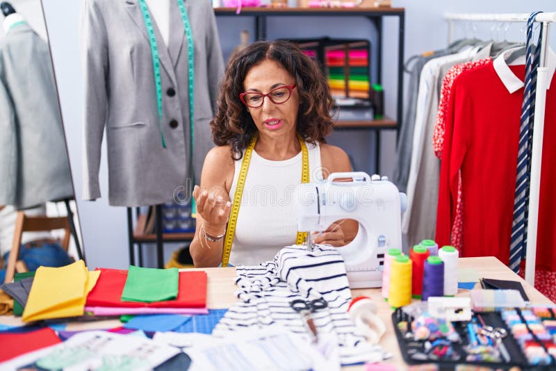 Middle Age Woman Tailor Using Sewing Machine Speaking at Clothing ...