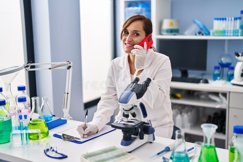 Middle Age Woman Wearing Scientist Uniform Talking on the Smartphone at ...