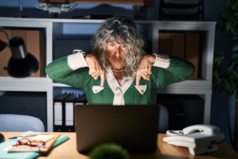 Middle Age Woman Working at Night Using Computer Laptop Pointing Down ...