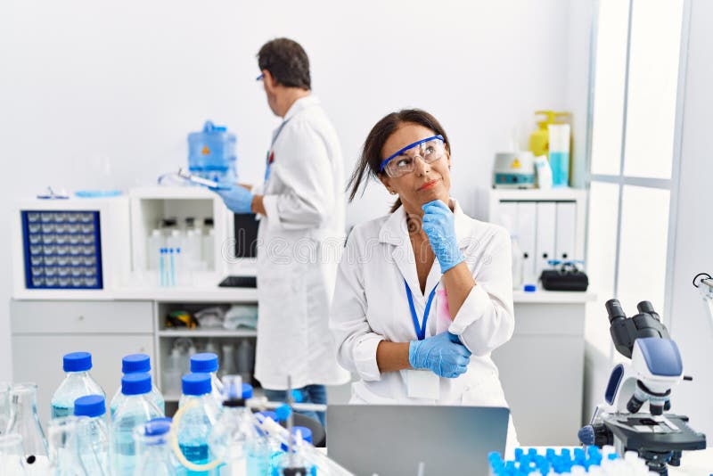 Middle Age Woman Working at Scientist Laboratory Serious Face Thinking ...