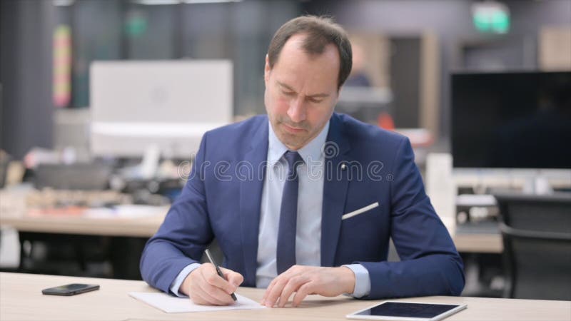 Businessman Writing on Paper in Office Stock Image - Image of signature ...