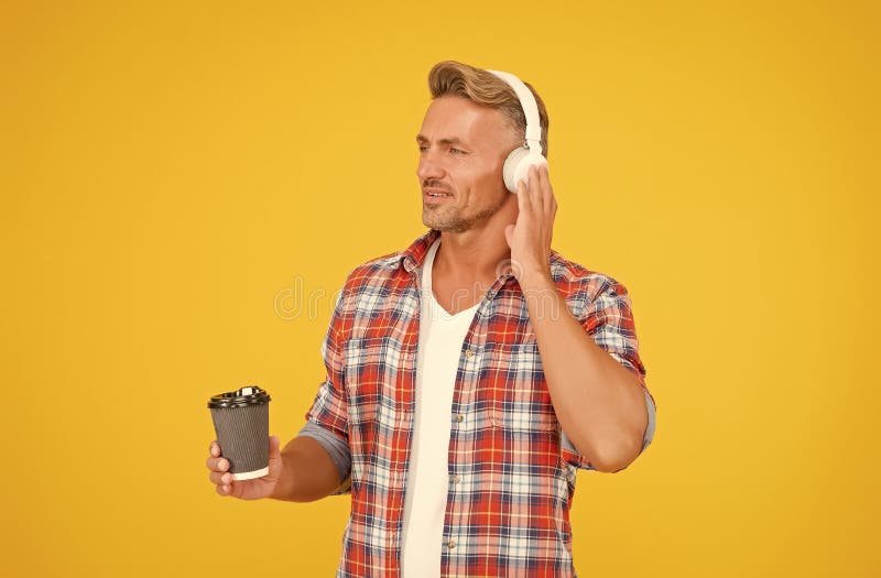 Middle Aged Caucasian Man Listen To Music In Earphones Holding Hot