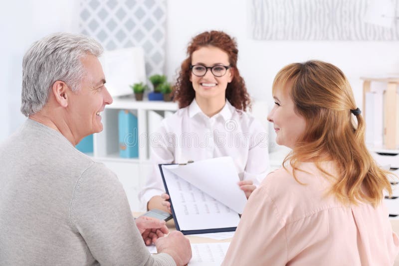 Middle Aged Couple Signing Contract at Insurance Agency Stock Image ... Middle Aged Couple Signing Contract at Insurance Agency Stock Image ...