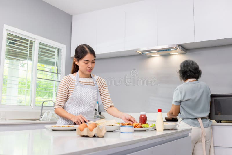 Middle Aged Daughter and Senior Mother Cooking Together at Kitchen ...