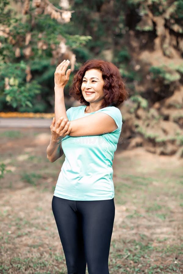 Middle Aged Elderly Active Woman Doing Exercise in a Park Outdoor Stock ...