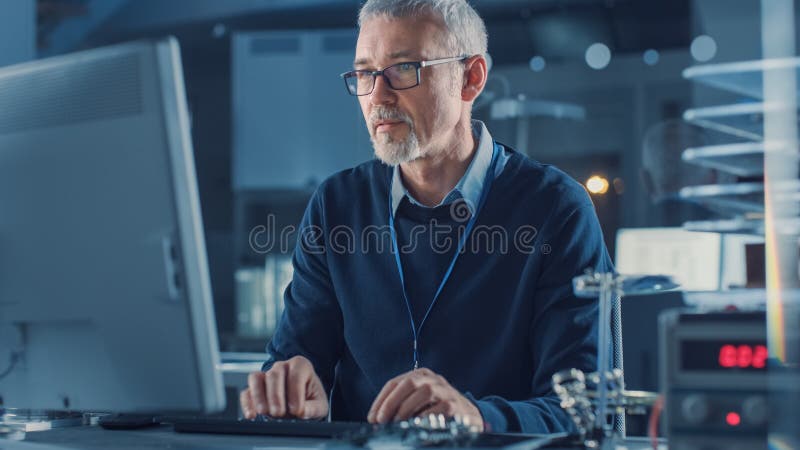 Middle Aged Electronics Repair Engineer Working on Personal Computer in ...