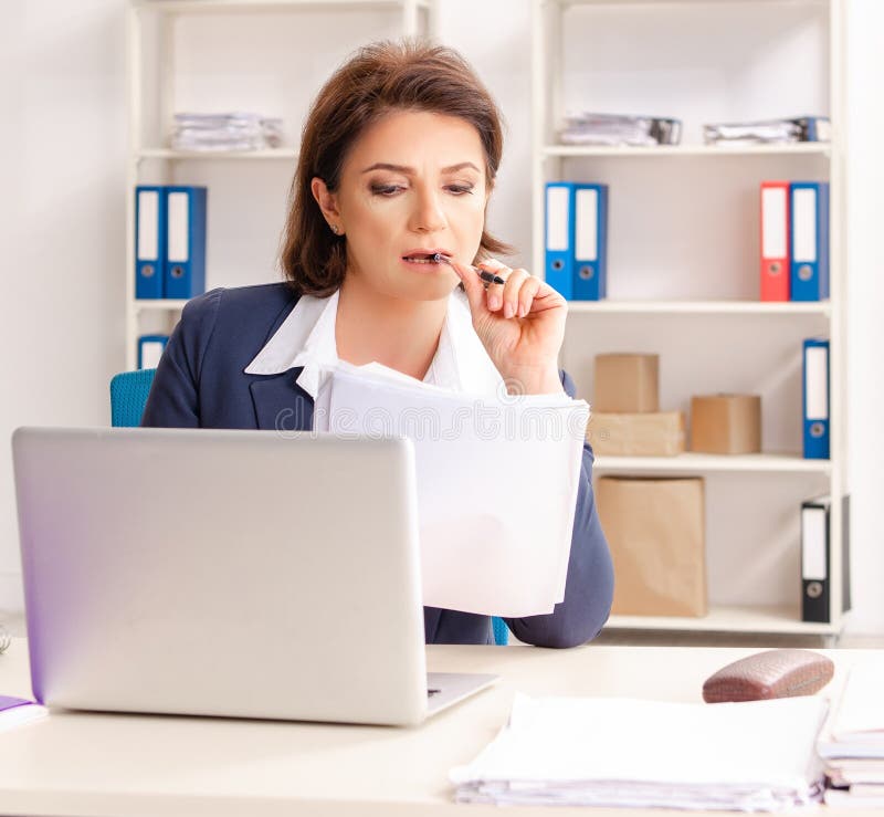 Middle-aged Female Employee Sitting at the Office Stock Photo - Image ...