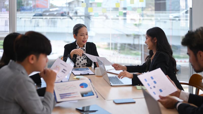 Middle Aged Female Team Leader Explaining Project Details, Discussing ...