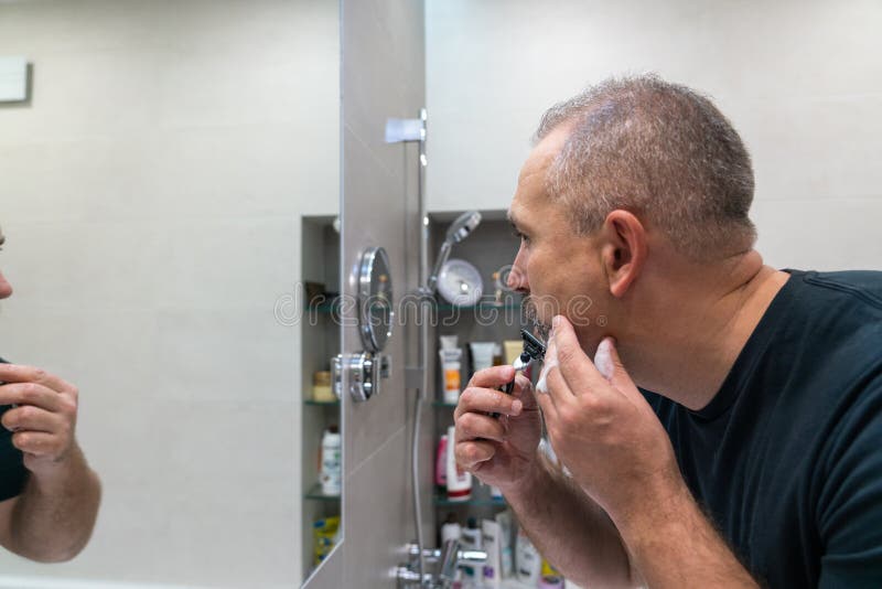 Middle-aged Handsome Man Using Razor in Bathroom Stock Photo - Image of ...
