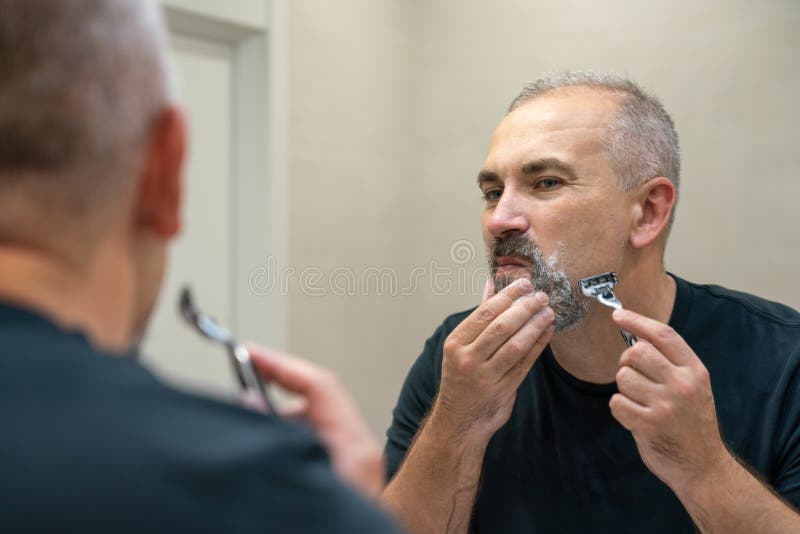 Middle-aged Handsome Man Using Razor in Bathroom Stock Photo - Image of ...