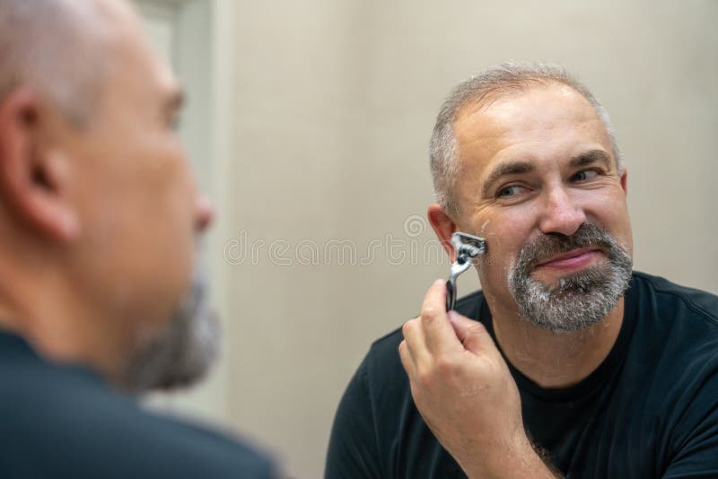 Middle-aged Handsome Man Using Razor in Bathroom Stock Photo - Image of ...