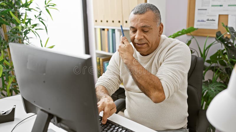 A Middle-aged Hispanic Man Working and Speaking on the Phone in an ...
