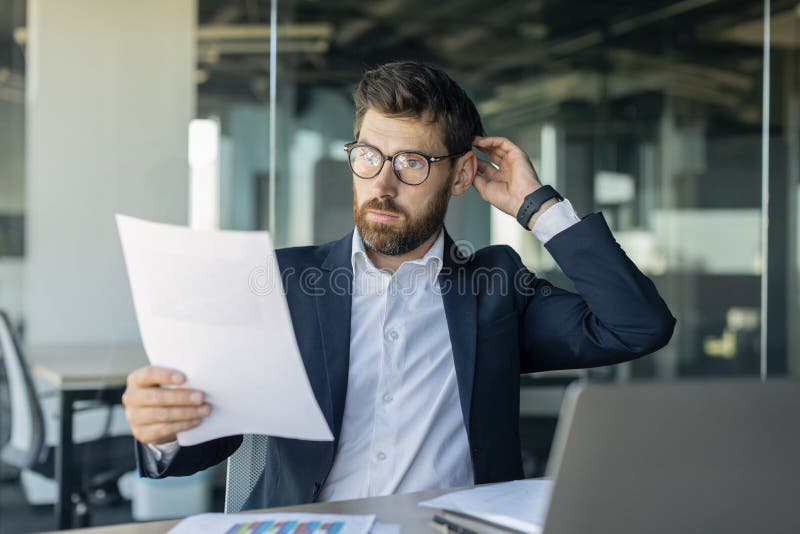 Middle Aged Male Manager with Documents Checking Marketing Report ...