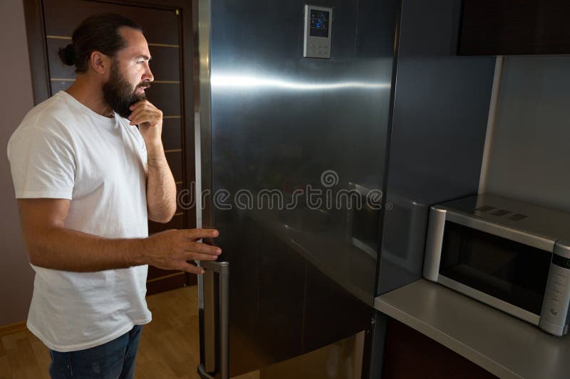 Middle-aged Male Stands, Thinking, in Front of a Refrigerator Stock ...