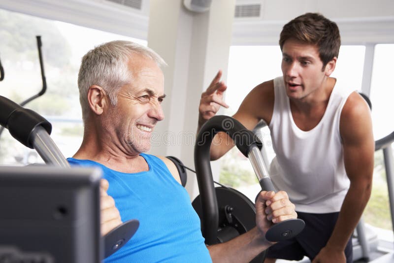 Middle Aged Man Being Encouraged by Personal Trainer in Gym Stock Image ...