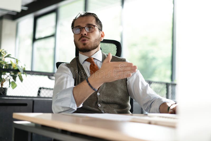 Middle-aged Man at a Desk Talking in an Office with Colleague, Smiling ...