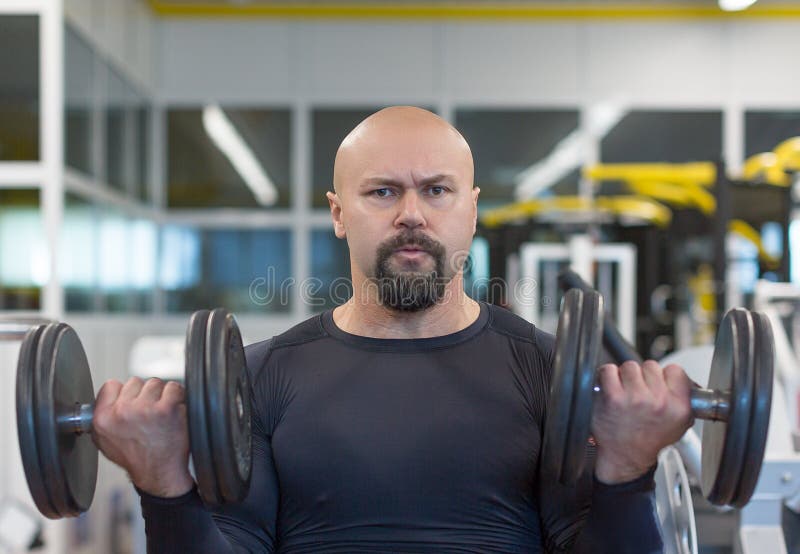 Middle-aged Man Doing Exercise for Bicepses with Dumbbells in Gym ...
