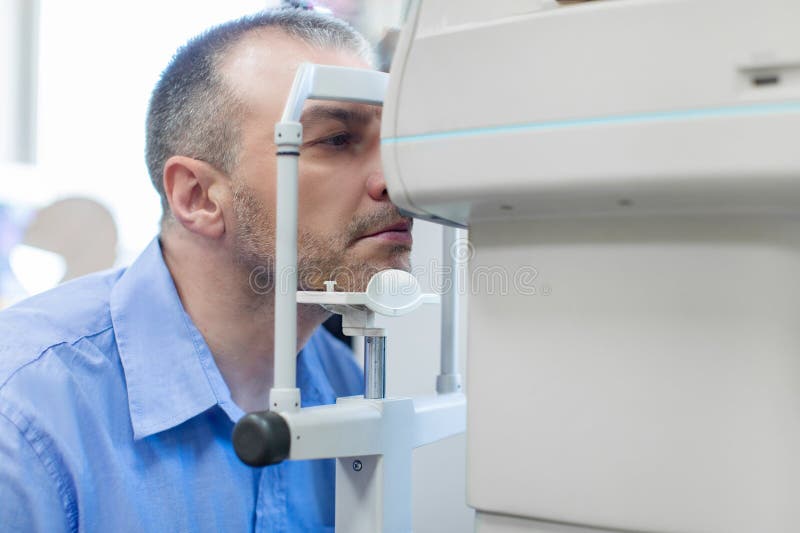 Middle Aged Man Examining Eyesight on Screen of Autorefractometer ...