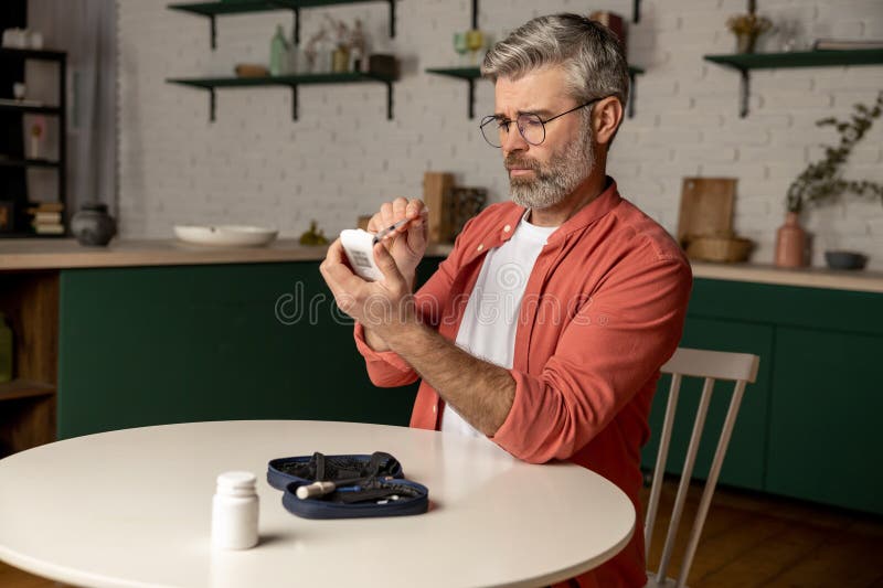 Middle Aged Man with Glucometer Checking Blood Sugar Level at Home ...