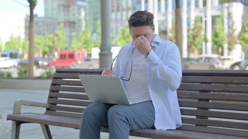 Man with Headache Using Laptop while Sitting Outdoor on Bench Stock ...