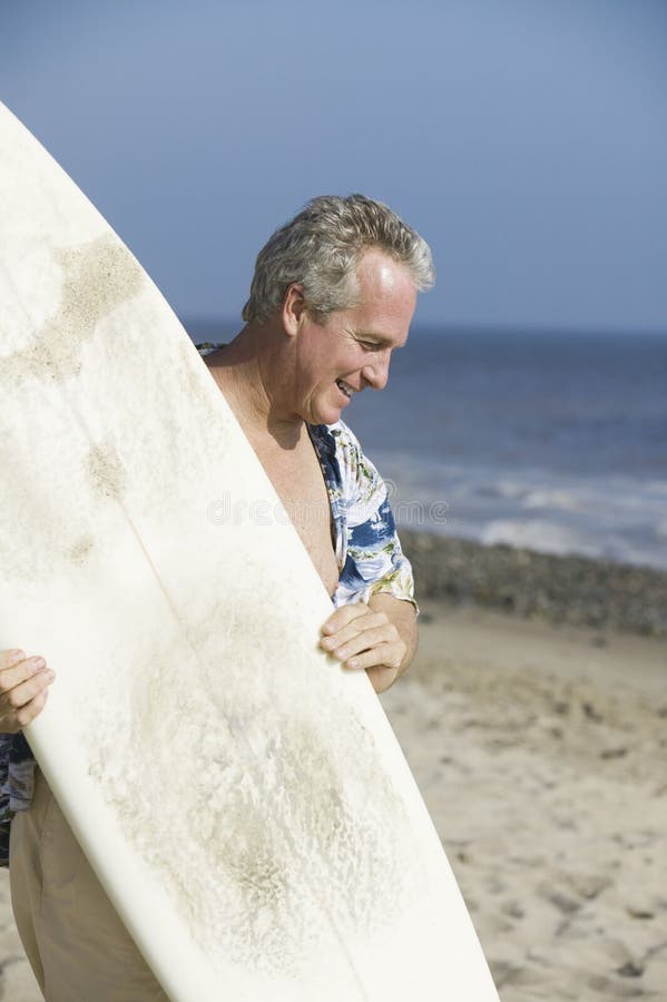 Male Surfer Carrying Surfboard on Beach Stock Photo - Image of sandy ...