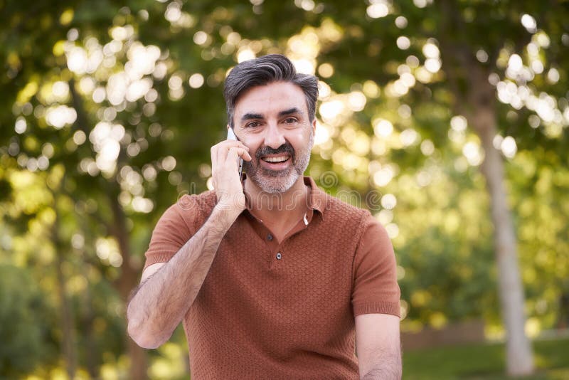 Middle-aged Man Looking at the Camera Smiling while Talking on the ...