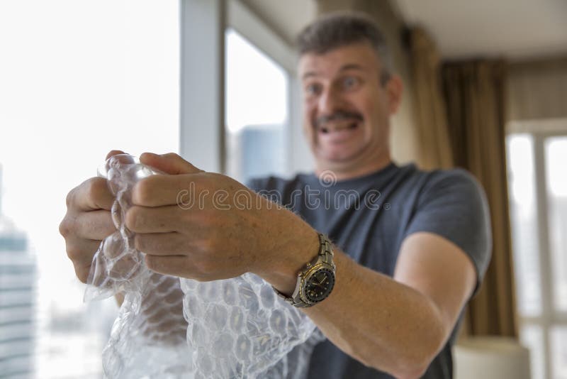 Middle Aged Man Popping Bubble Wrap Stock Photo - Image of alone ...