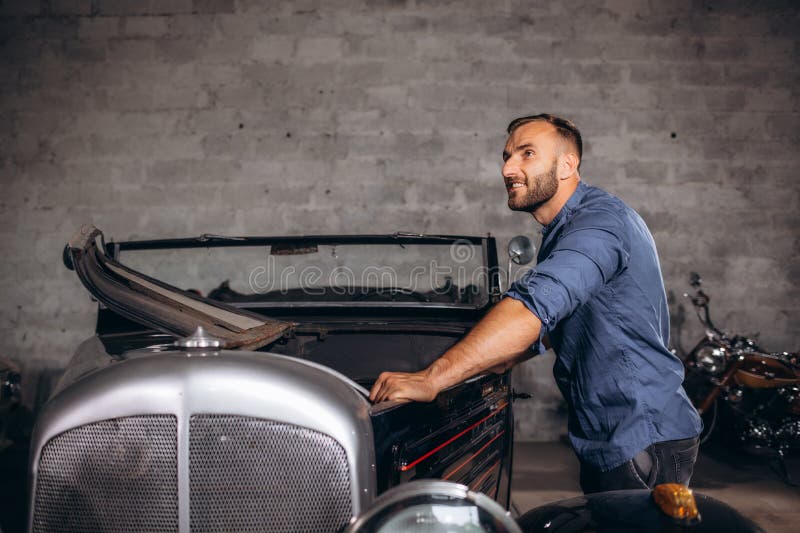 A Middle-aged Man Repairs His Retro Car in the Garage Stock Image ...