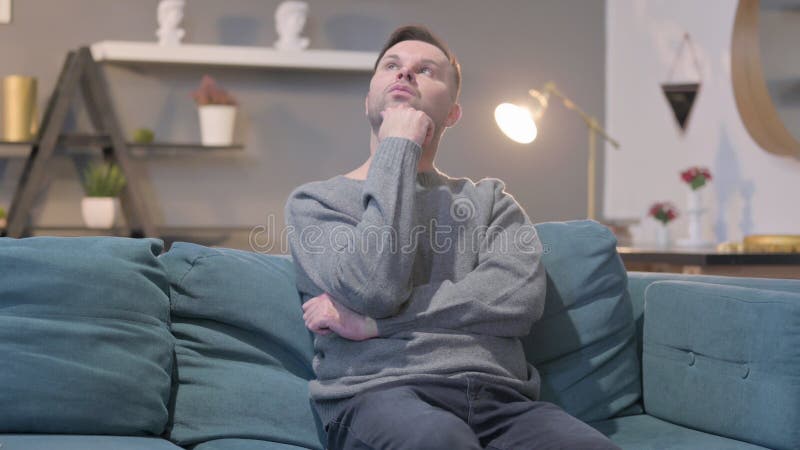 Casual Man Thinking while Sitting on Sofa Stock Image - Image of home ...