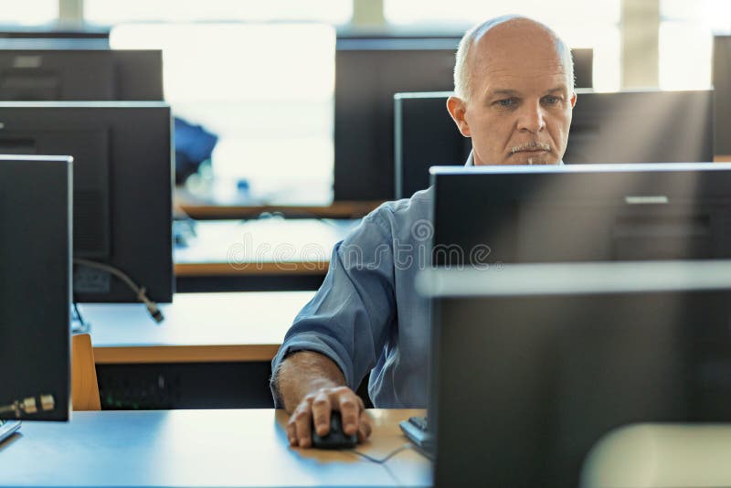 Middle-aged Man Uses a Desktop PC Workstation in a Common Room Stock ...