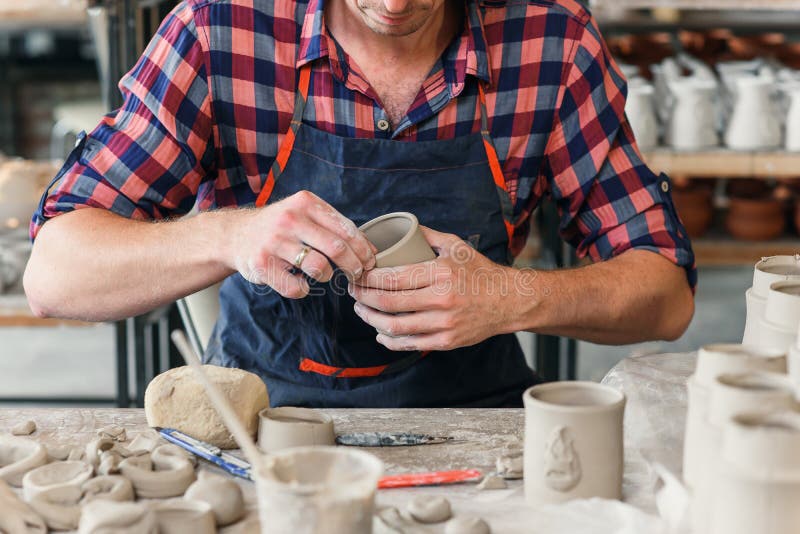 A Middle-aged Man in a Work Uniform Make a Clay Shape of Cup in a Large ...