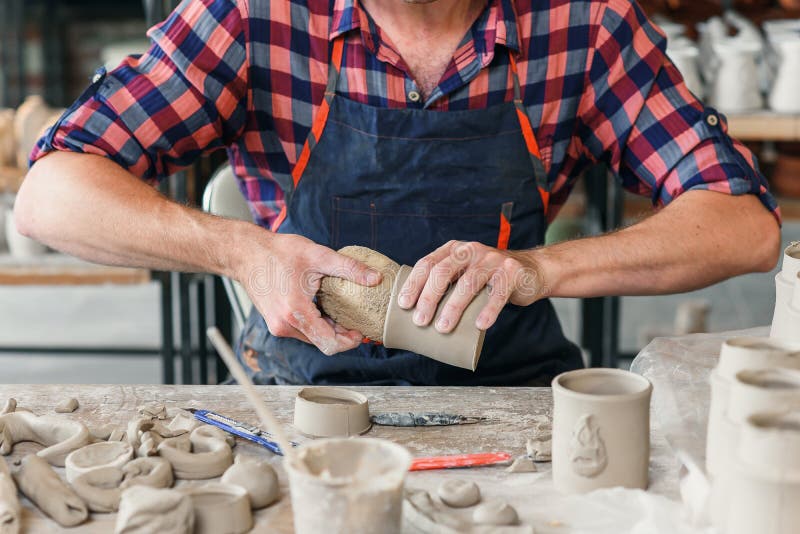 A Middle-aged Man in a Work Uniform Wipes with a Damp Sponge a Clay ...