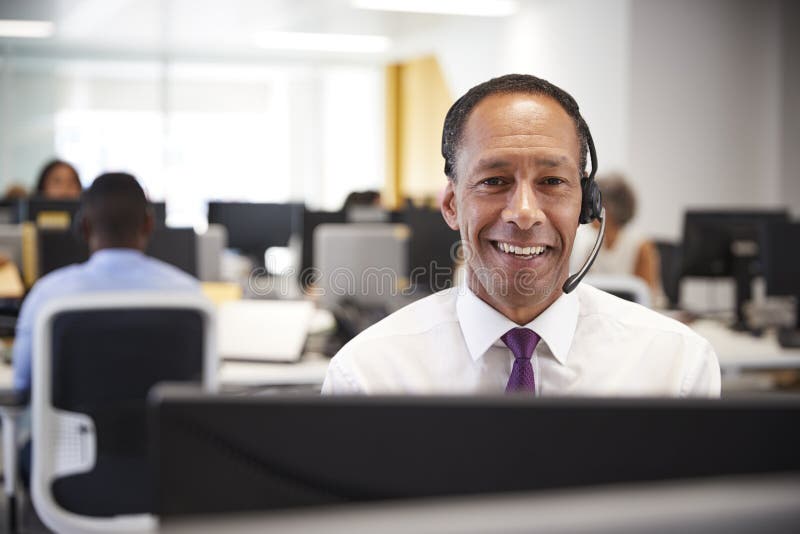 Middle Aged Man Working at Computer with Headset in Office Stock Image ...