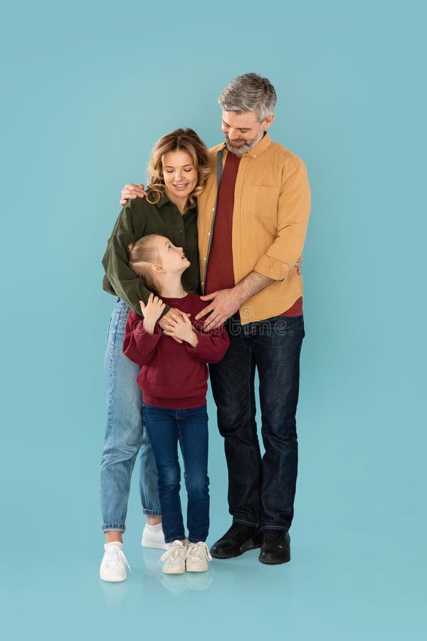 Middle Aged Parents Embracing Daughter Smiling Standing Together in ... Middle Aged Parents Embracing Daughter Smiling Standing Together in ...