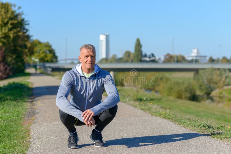 Middle Aged Runner Sitting in a Squat Stock Photo - Image of active ...