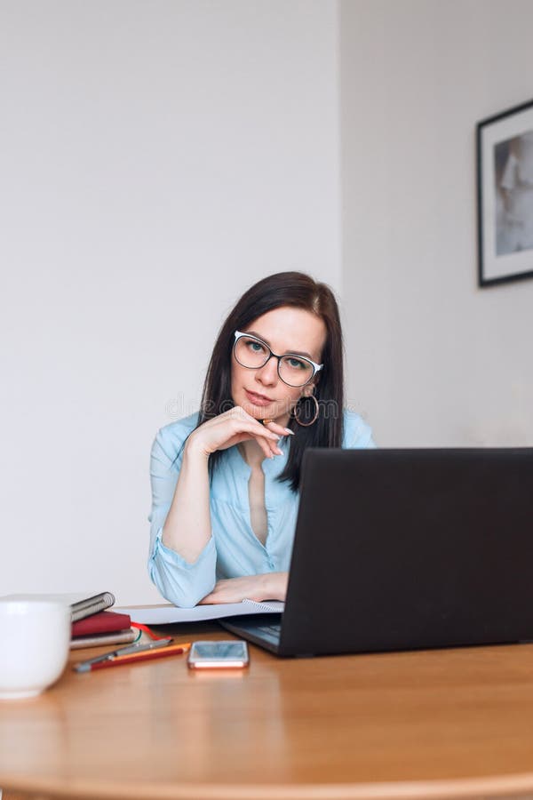Middle Aged Woman Sitting at a Table Reading Using a Computer at Home ...