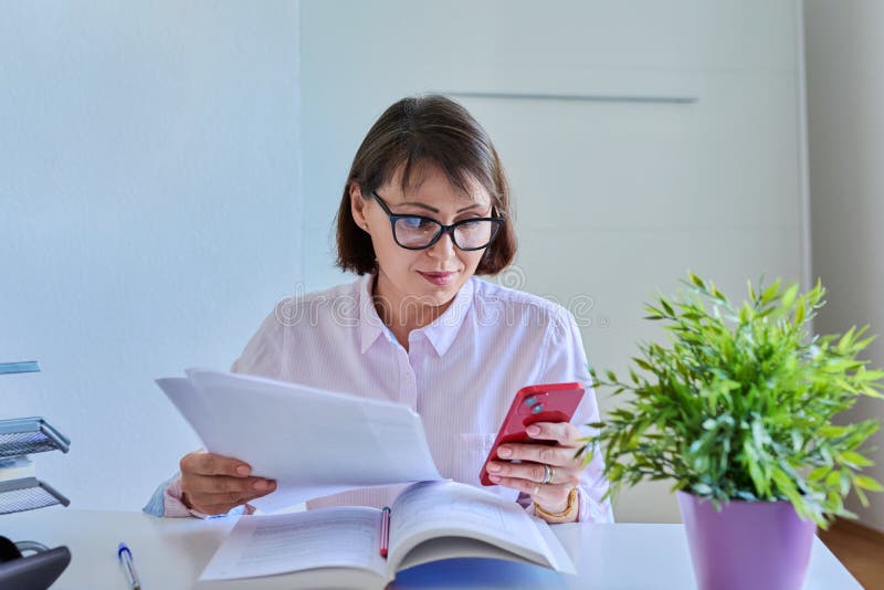 Middle Aged Woman Sitting at Workplace Using Smartphone in Home Office ...
