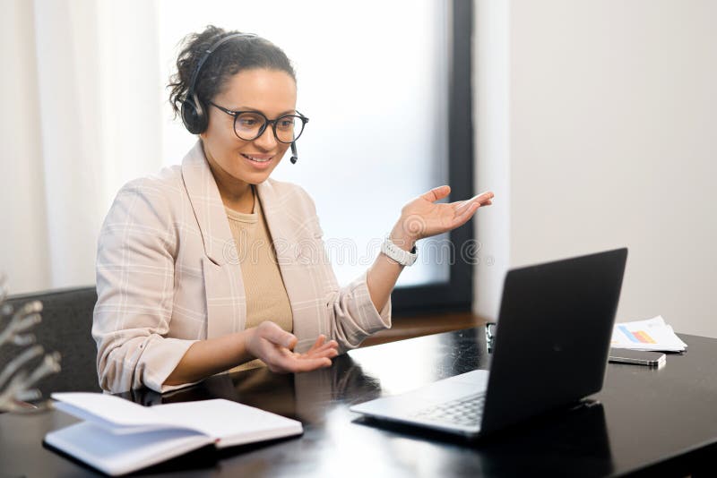 Middle-aged Woman Wearing Wireless Headset Using a Laptop Computer for ...