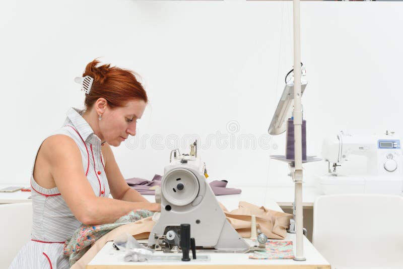 Middle Aged Woman Works at a Sewing Machine in a Sewing Workshop Stock ...