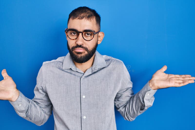 Middle East Man with Beard Standing Over Blue Background Clueless and ...