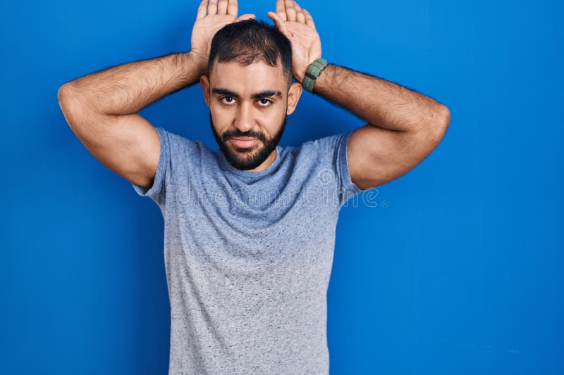 Middle East Man with Beard Standing Over Blue Background Doing Bunny ...