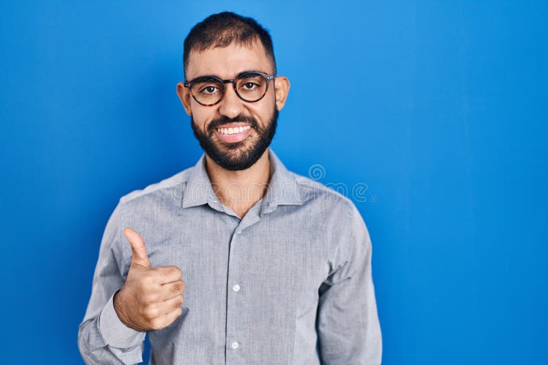 Middle East Man with Beard Standing Over Blue Background Doing Happy ...