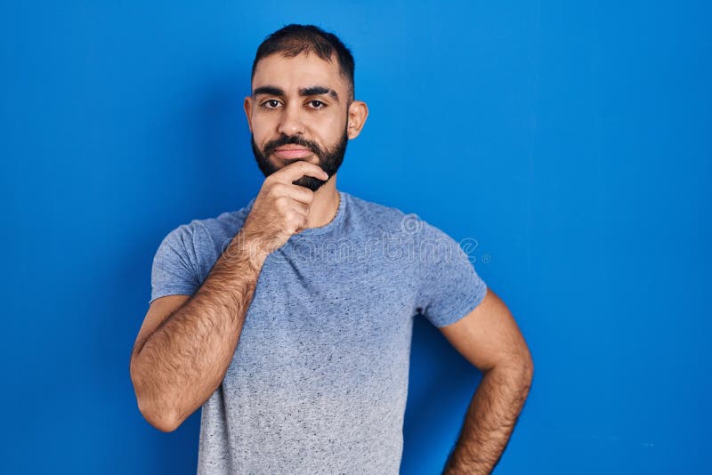 Middle East Man with Beard Standing Over Blue Background with Hand on ...