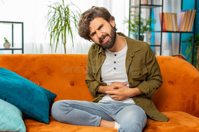 Arabian Man Sits on Sofa Feeling Sudden Strong Abdominal Stomach Ache ...