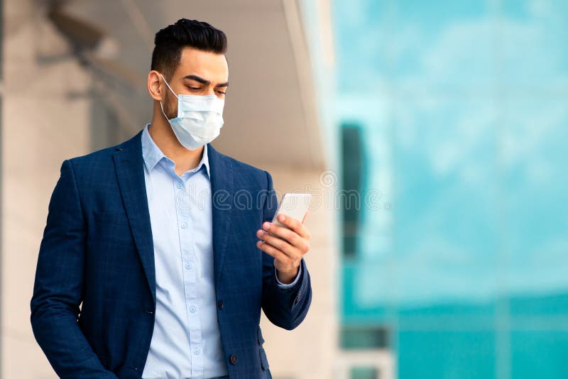 Middle Eastern Entrepreneur in Face Mask Using Phone while Walking ...